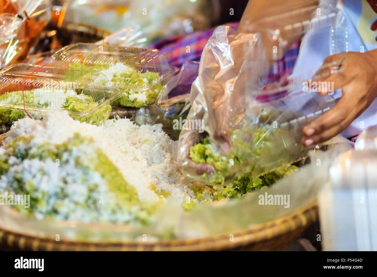 Thai vendor is selling shredded rice grain dessert to the customer at ...