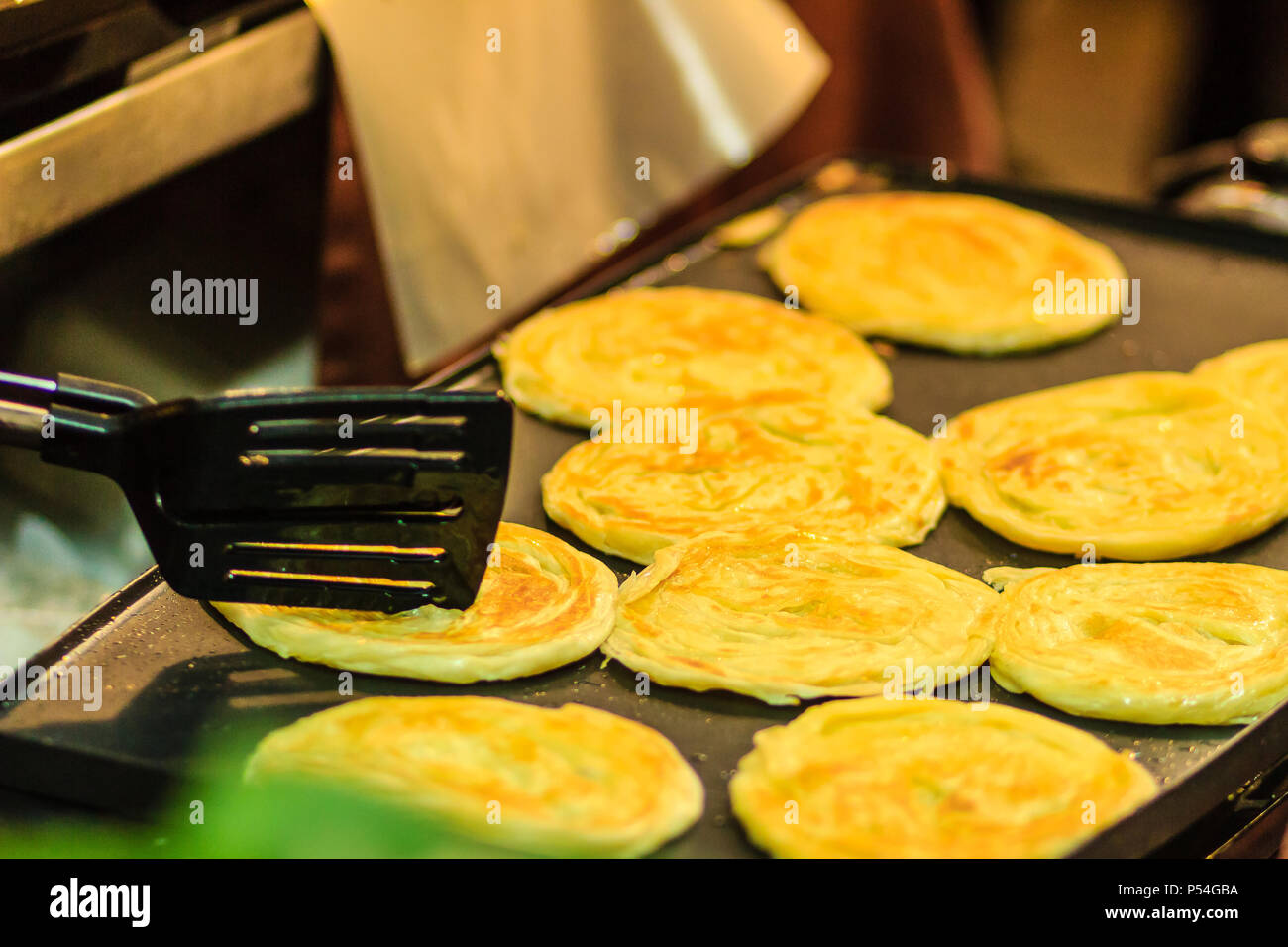 Close up vendor cooking for southern flat bread, mataba, or roti, the ...