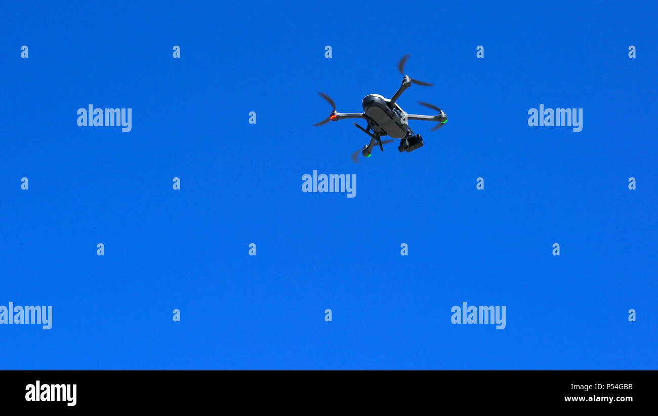 Drone taking off against a bright blue summer sky, with copy space ...