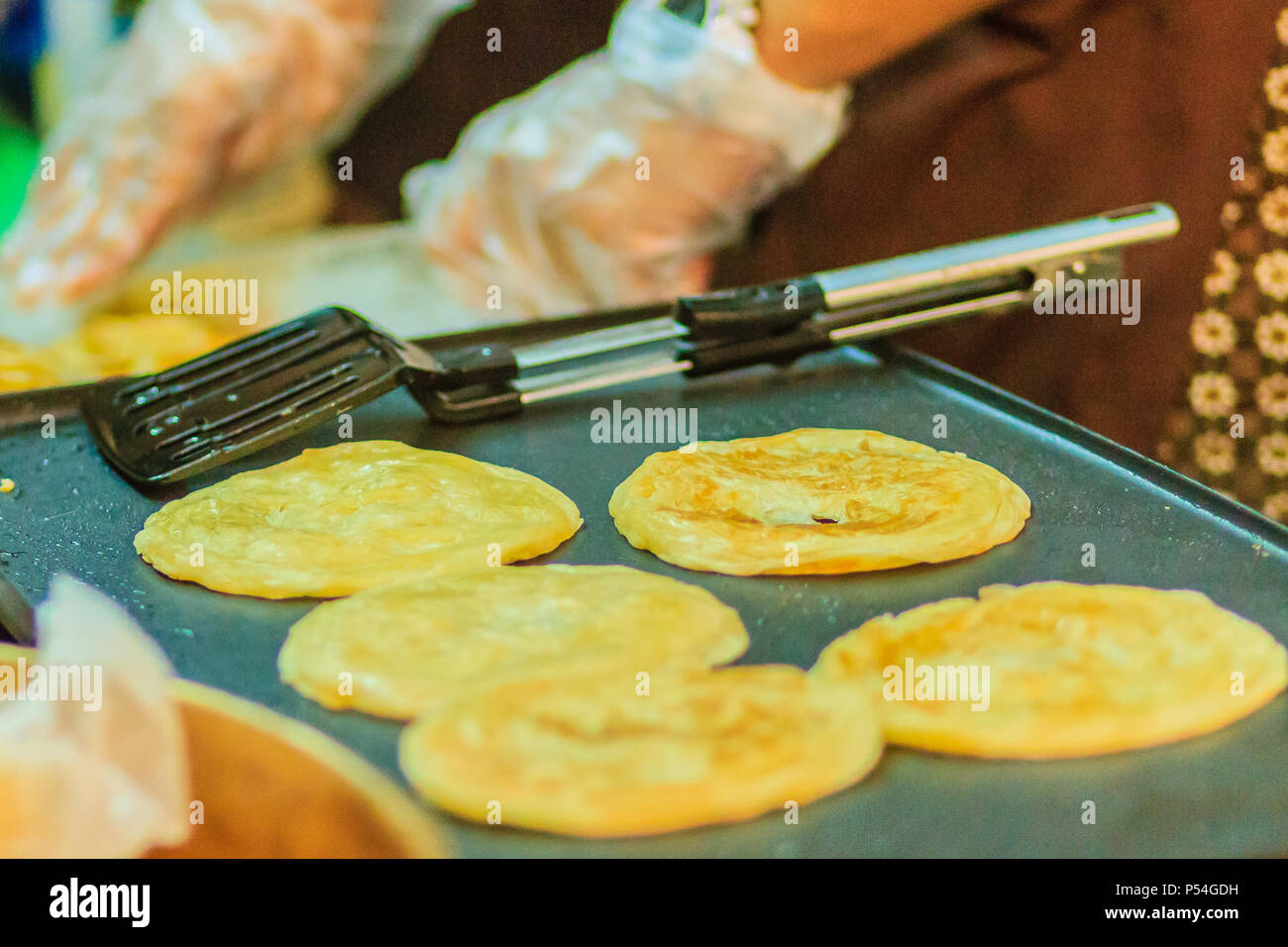 Close up vendor cooking for southern flat bread, mataba, or roti, the ...