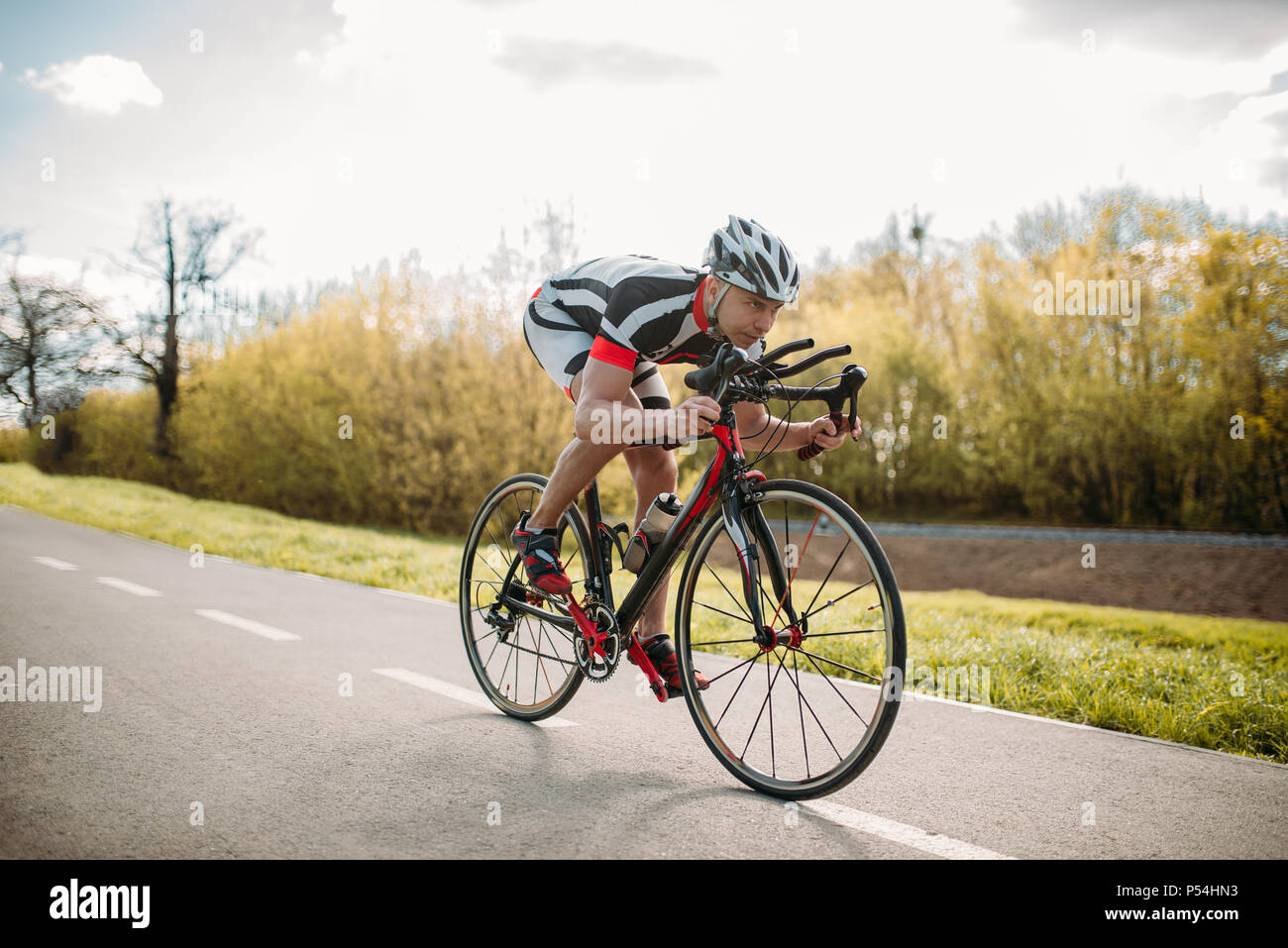 Male cyclist in helmet and sportswear rides on bicycle, front view ...
