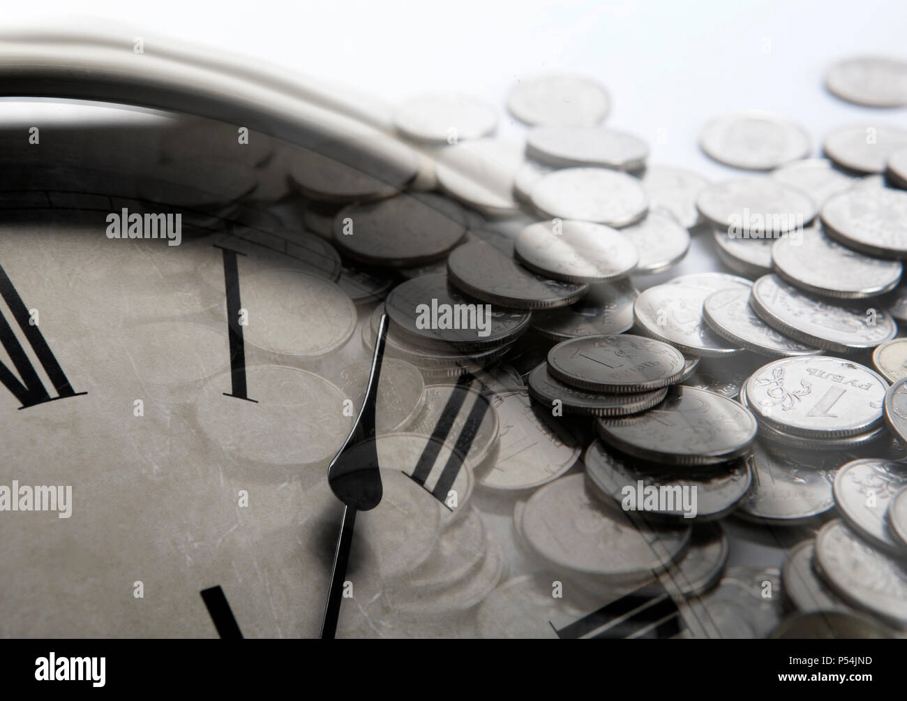 pile of coins with clock face close up Stock Photo - Alamy