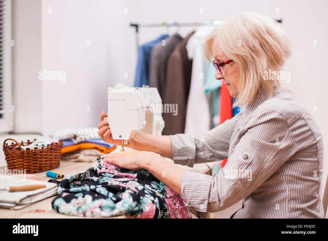 Adult woman is sewing in her studio Stock Photo - Alamy