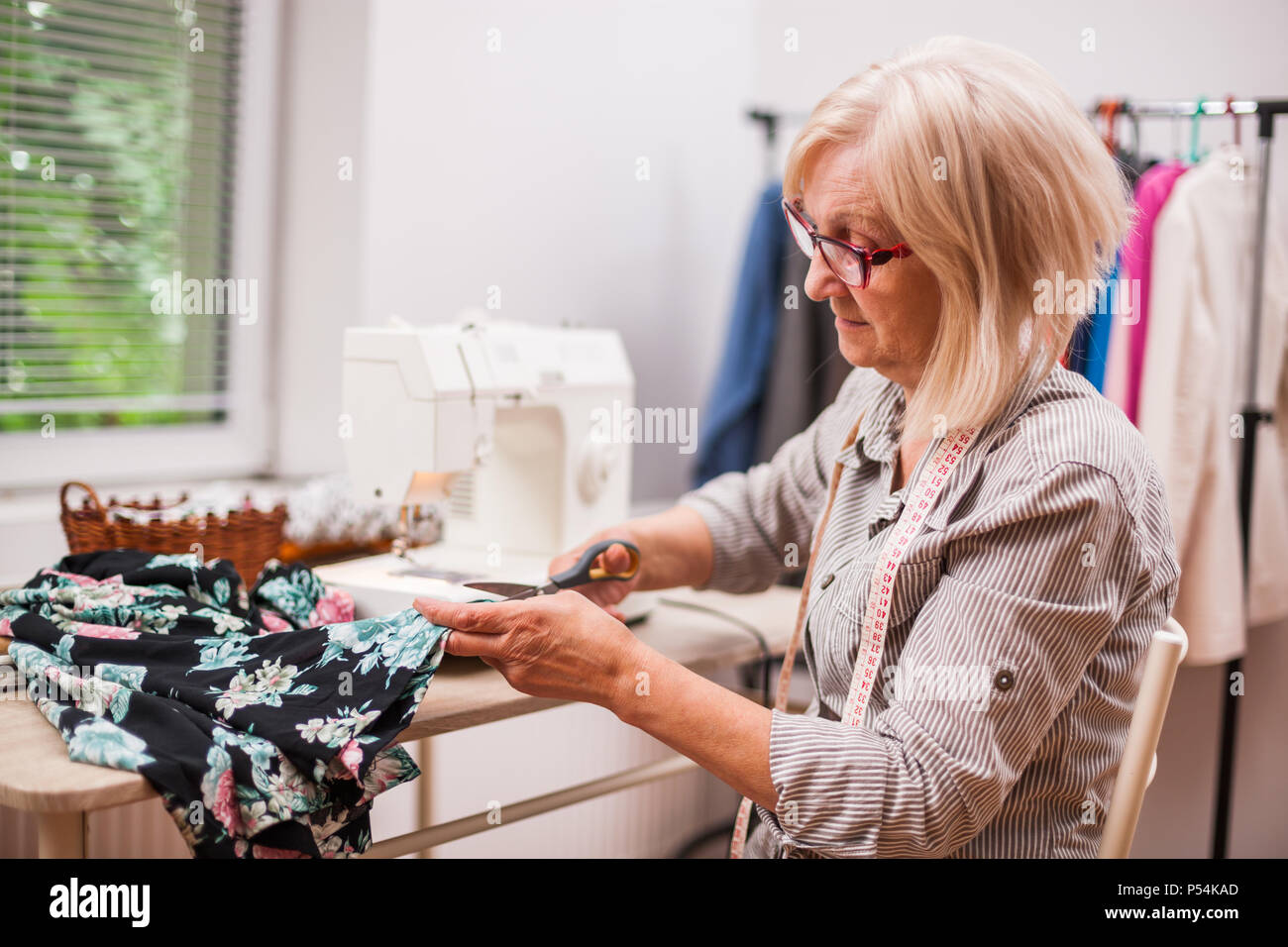 Adult woman is sewing in her studio Stock Photo - Alamy