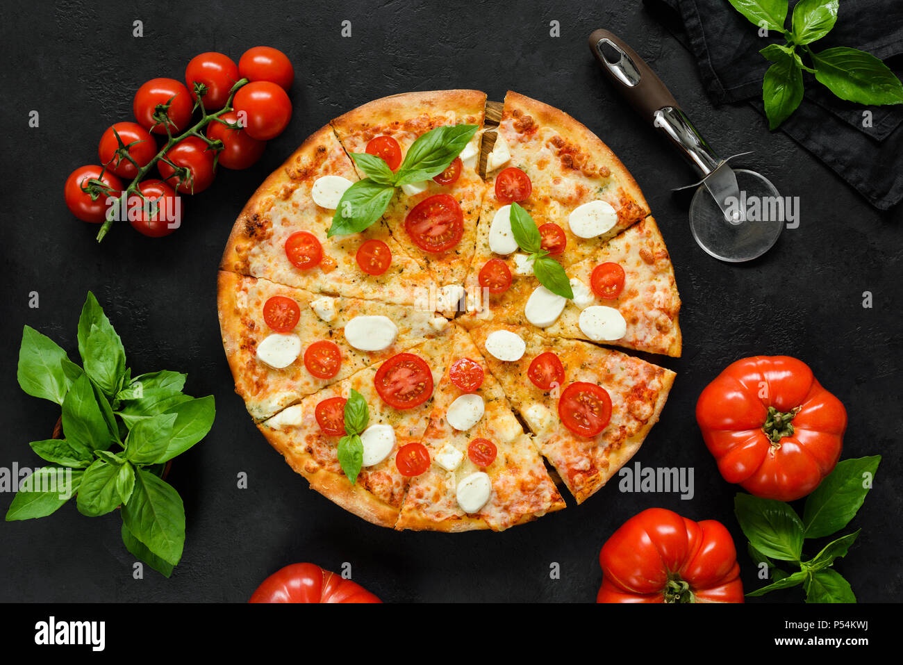 Homemade italian pizza with mozzarella, tomatoes and basil on black ...