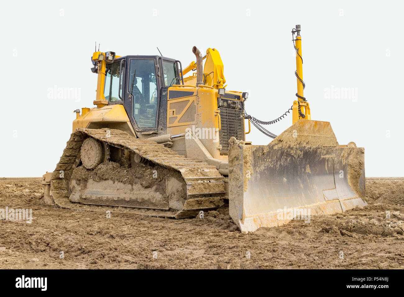 yellow bulldozer at a loamy construction site, partly isolated in white ...