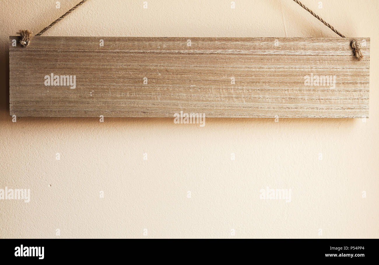 Abstract composition of small wooden board hanged on wall with ropes ...