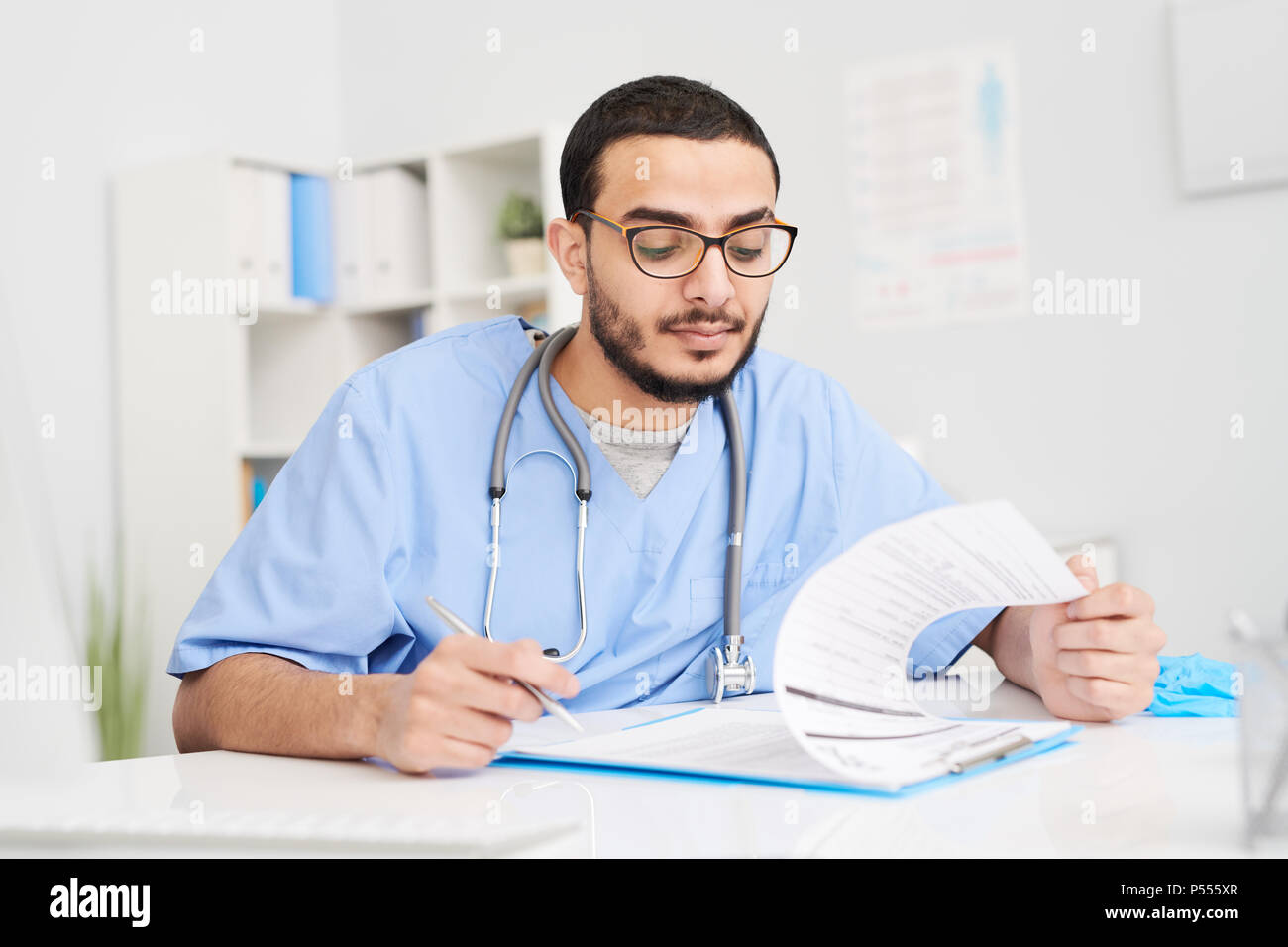 Doctor filling in checkup document hi-res stock photography and images ...