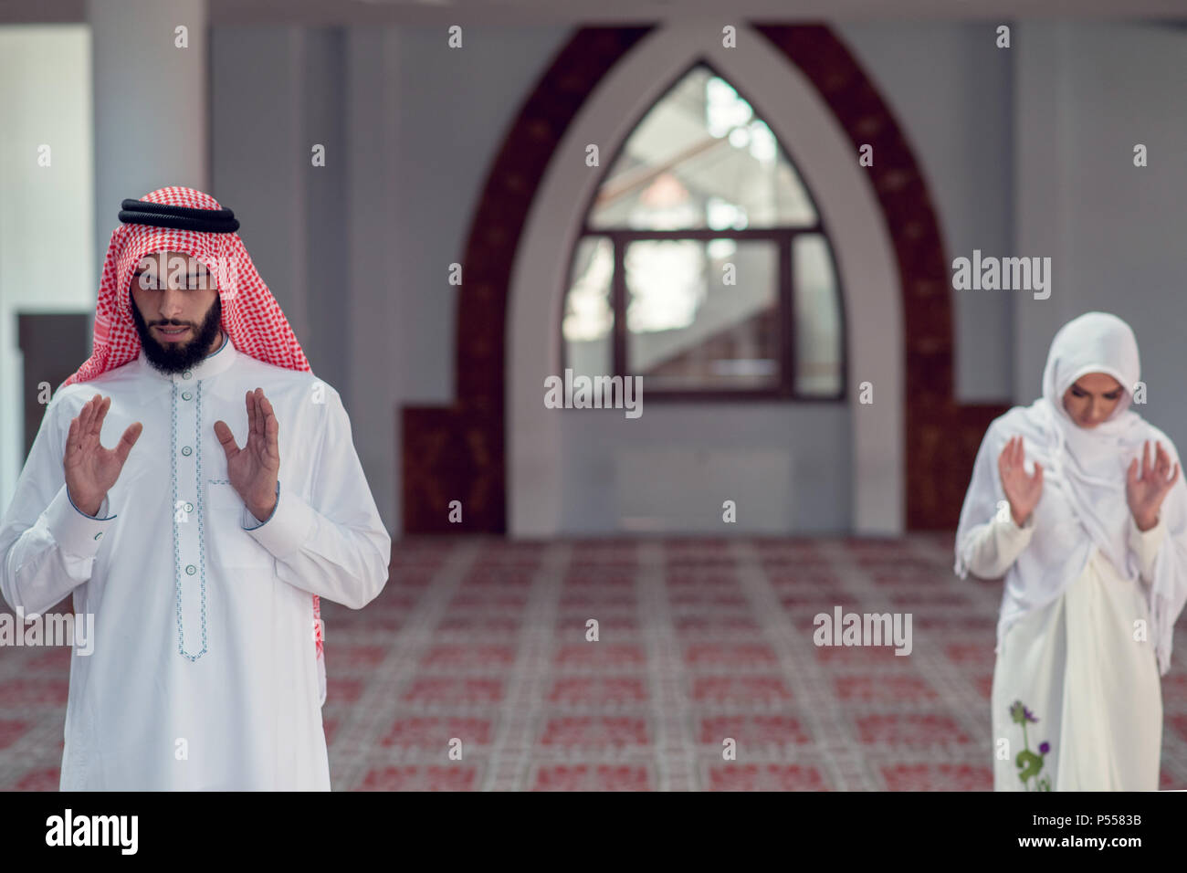 Muslim man and woman praying for Allah in the mosque together Stock ...