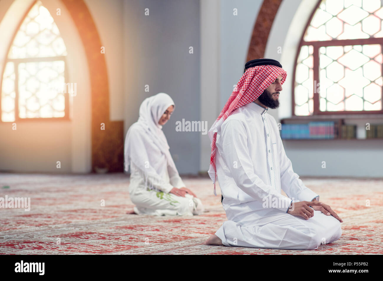 Muslim man and woman praying for Allah in the mosque together Stock ...