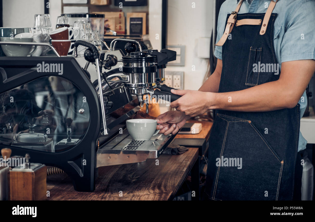 Close up male barista making hot coffee with machine at counter bar in ...