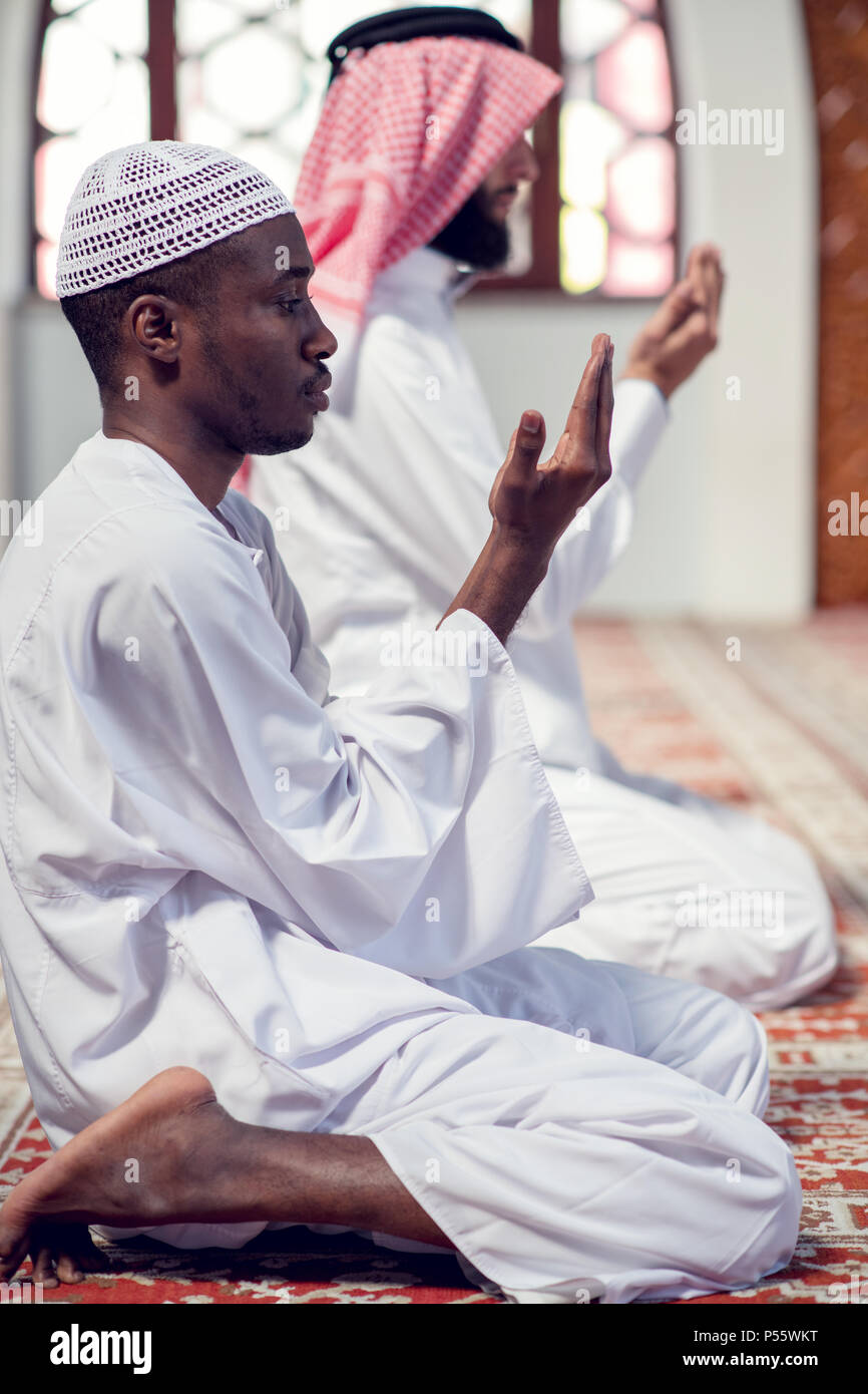 Two religious muslim man praying together inside the mosque Stock Photo ...