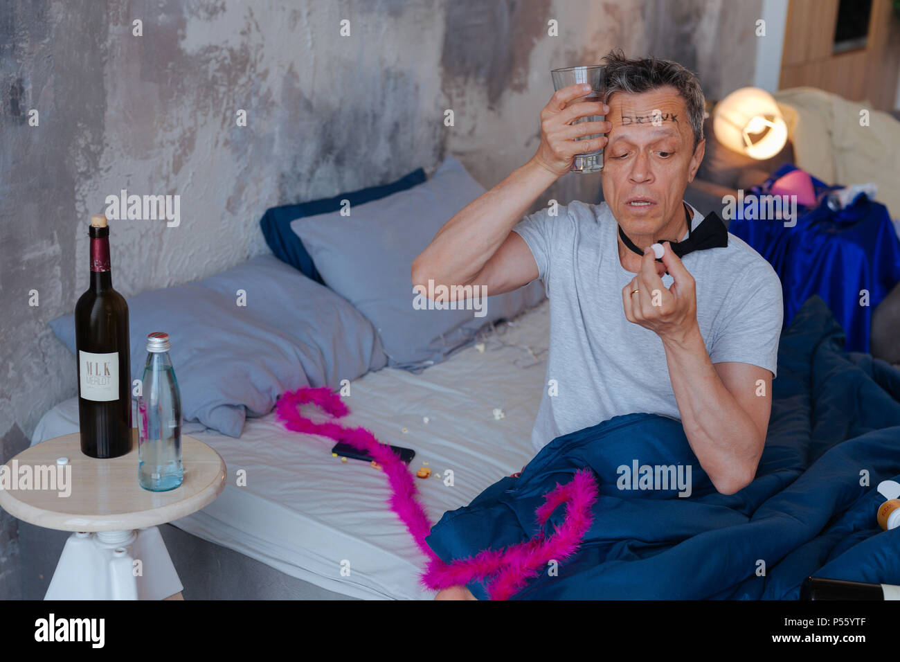 Pinched mature man improving condition Stock Photo - Alamy