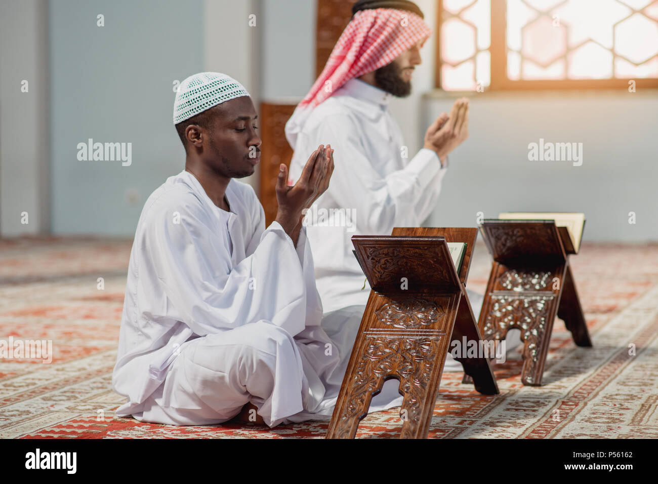 Two religious muslim man praying together inside the mosque Stock Photo ...