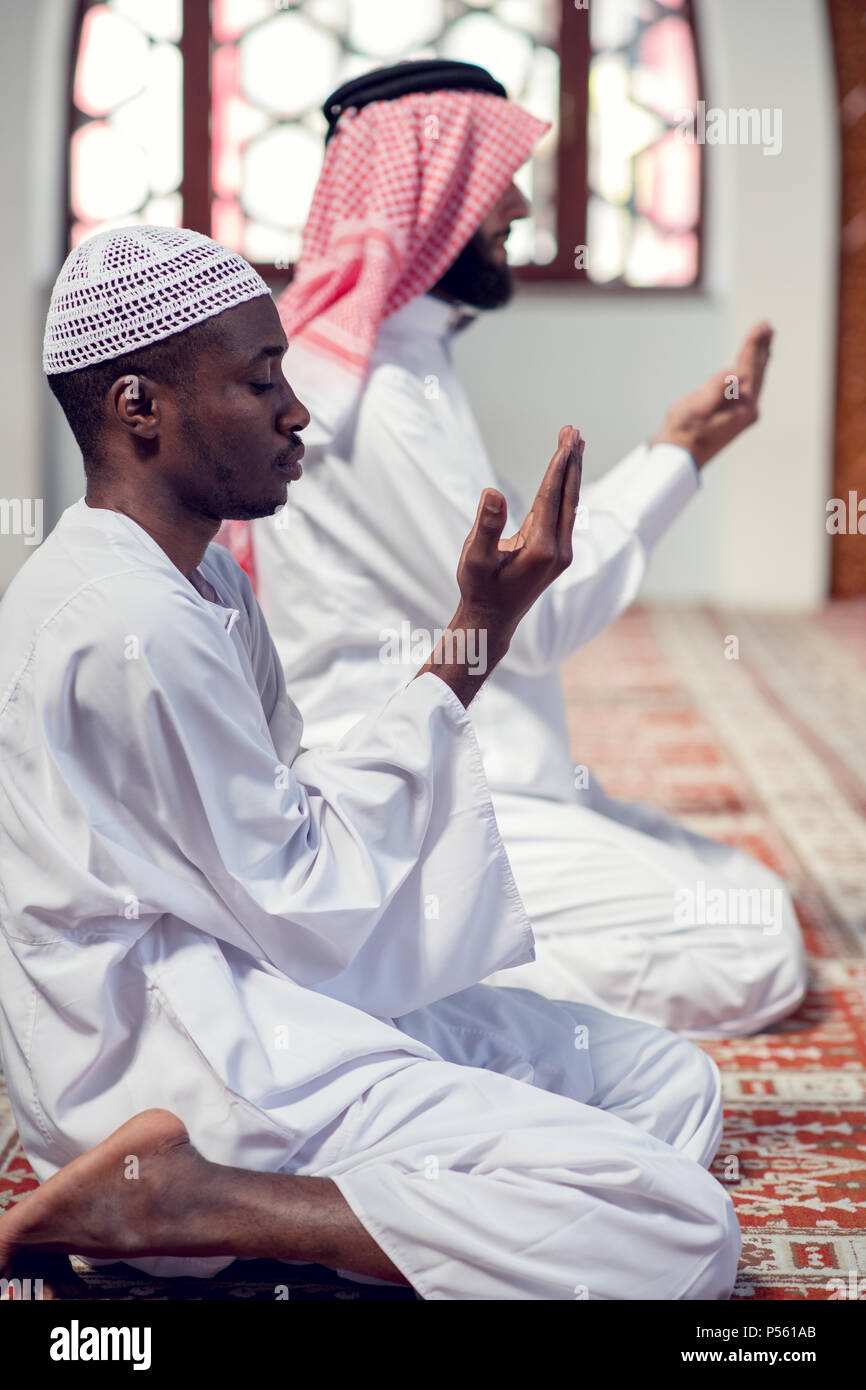 Two religious muslim man praying together inside the mosque Stock Photo ...