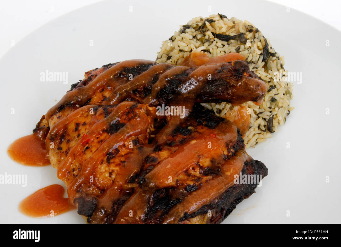 Jamaican jerk chicken with callaloo rice hi-res stock photography and ...