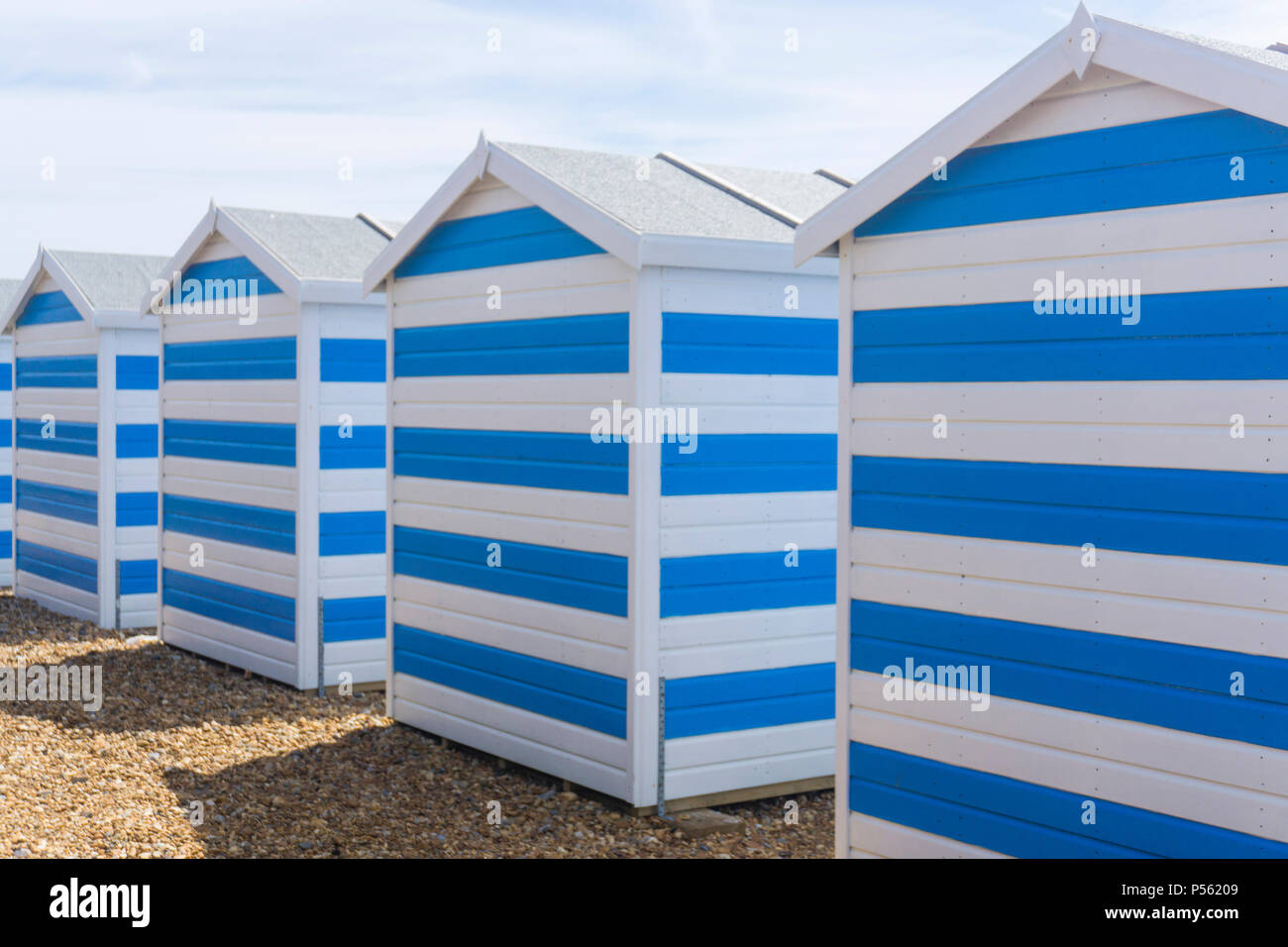 Blue and white striped beach huts at the seaside Stock Photo - Alamy