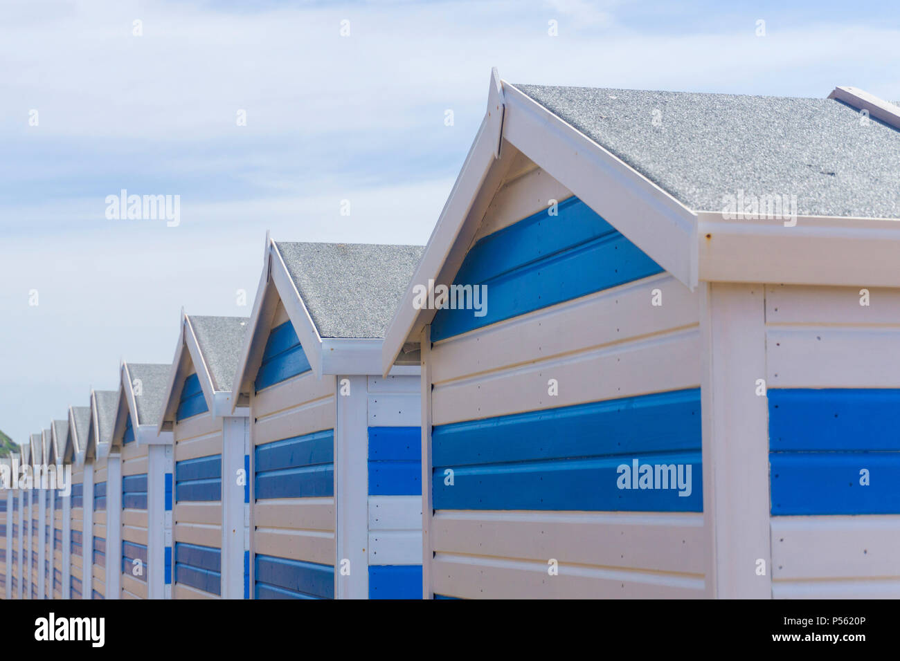 Blue and white striped beach huts at the seaside Stock Photo - Alamy