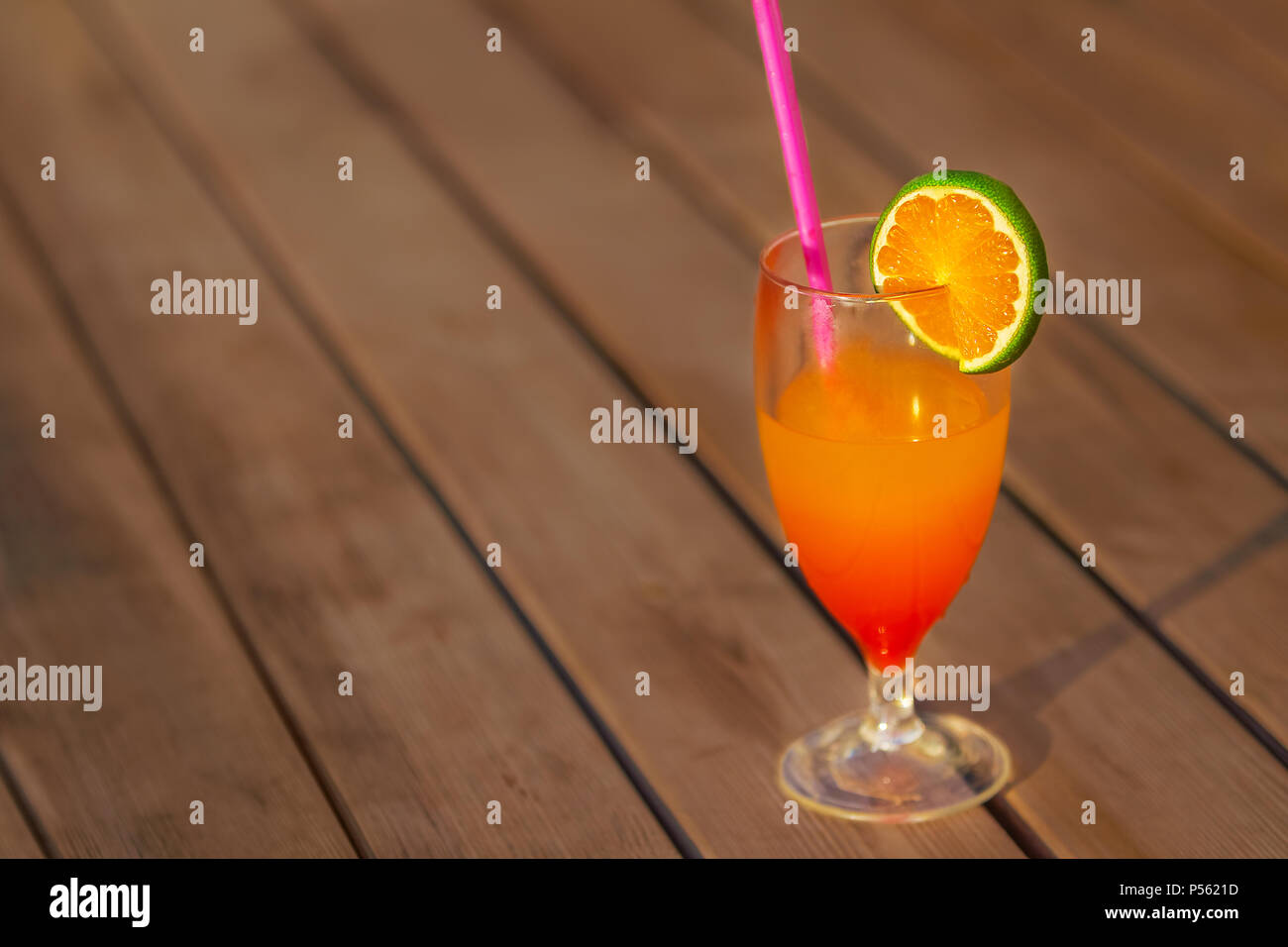 cocktail with an orange in glass on the floor near a pool Stock Photo ...