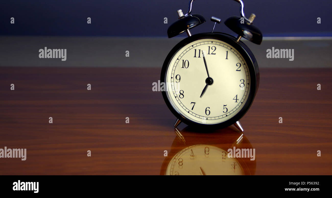 Classic style alarm clock on table with reflection Stock Photo - Alamy
