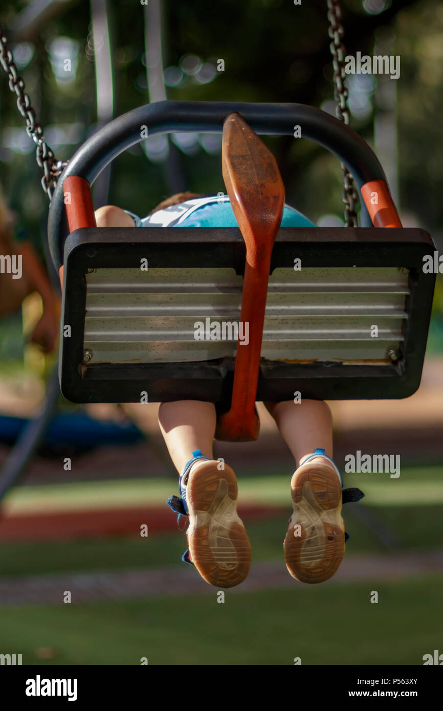 A child swinging on a children's swing Stock Photo - Alamy