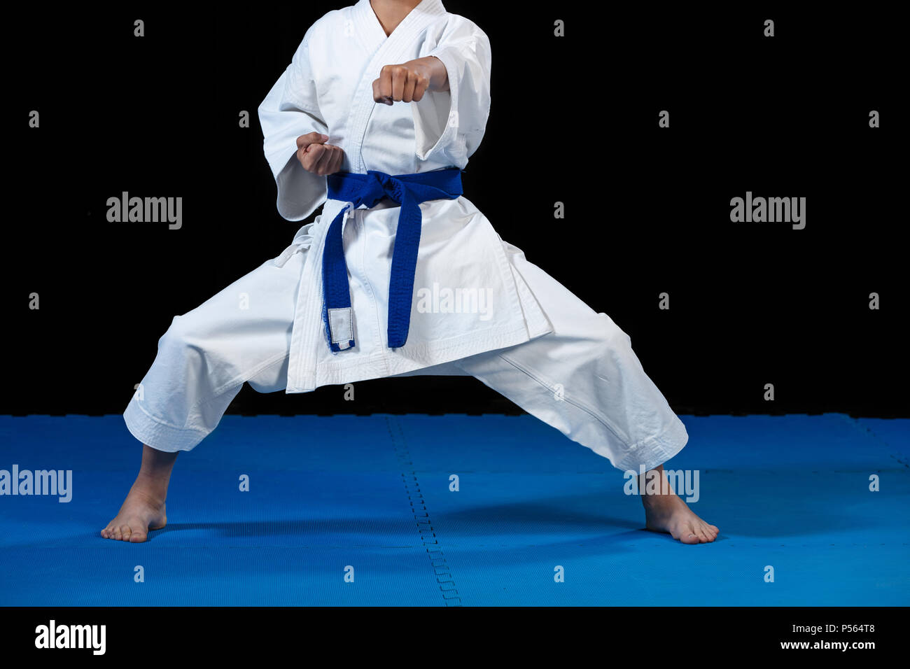 Pre-teen boy doing karate on a black background Stock Photo - Alamy
