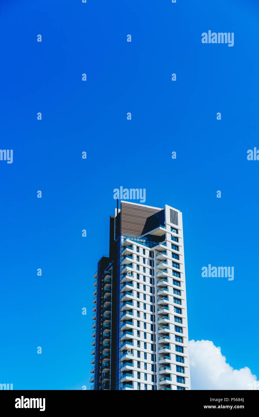 Solo building with a low cloud and a bright blue sky in Tel Aviv Israel ...