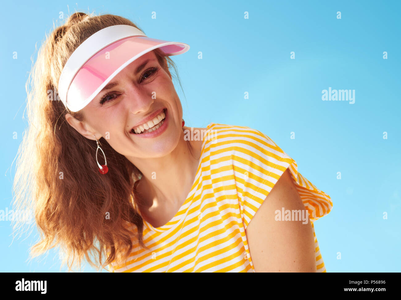 happy active woman in yellow shirt against blue sky Stock Photo - Alamy