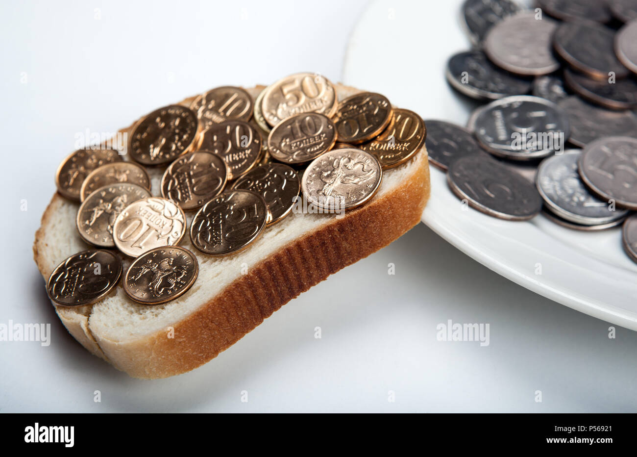Plate with coins and a slice of bread with coins Stock Photo - Alamy