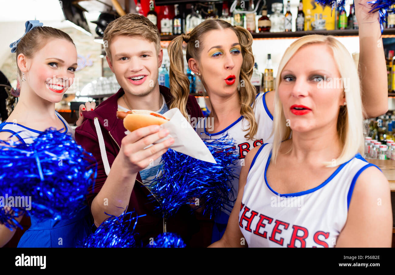 Young sports fans watching a game and drinking beer Stock Photo - Alamy