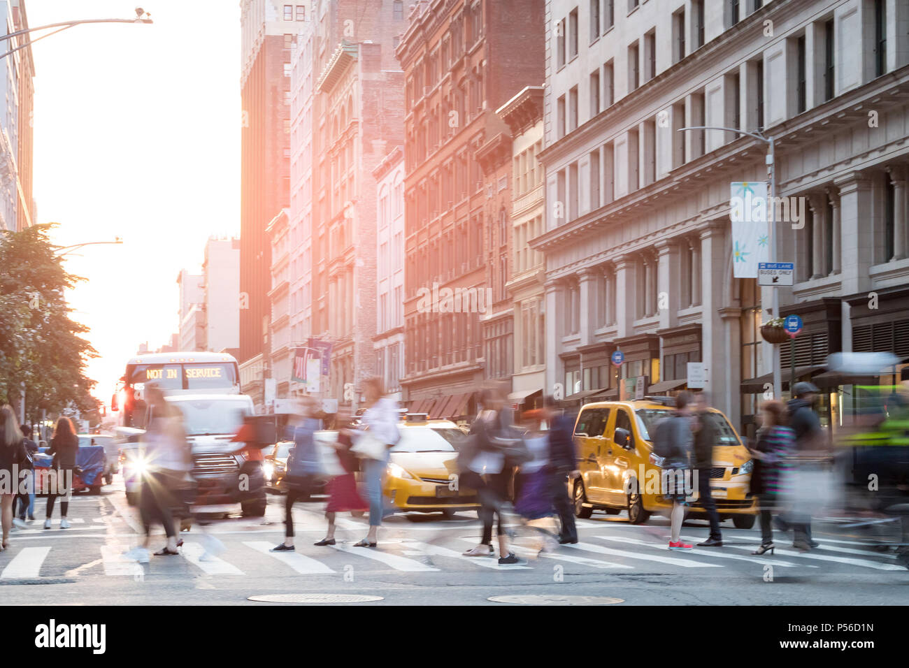 Busy people in motion across an intersection on Broadway in New York ...