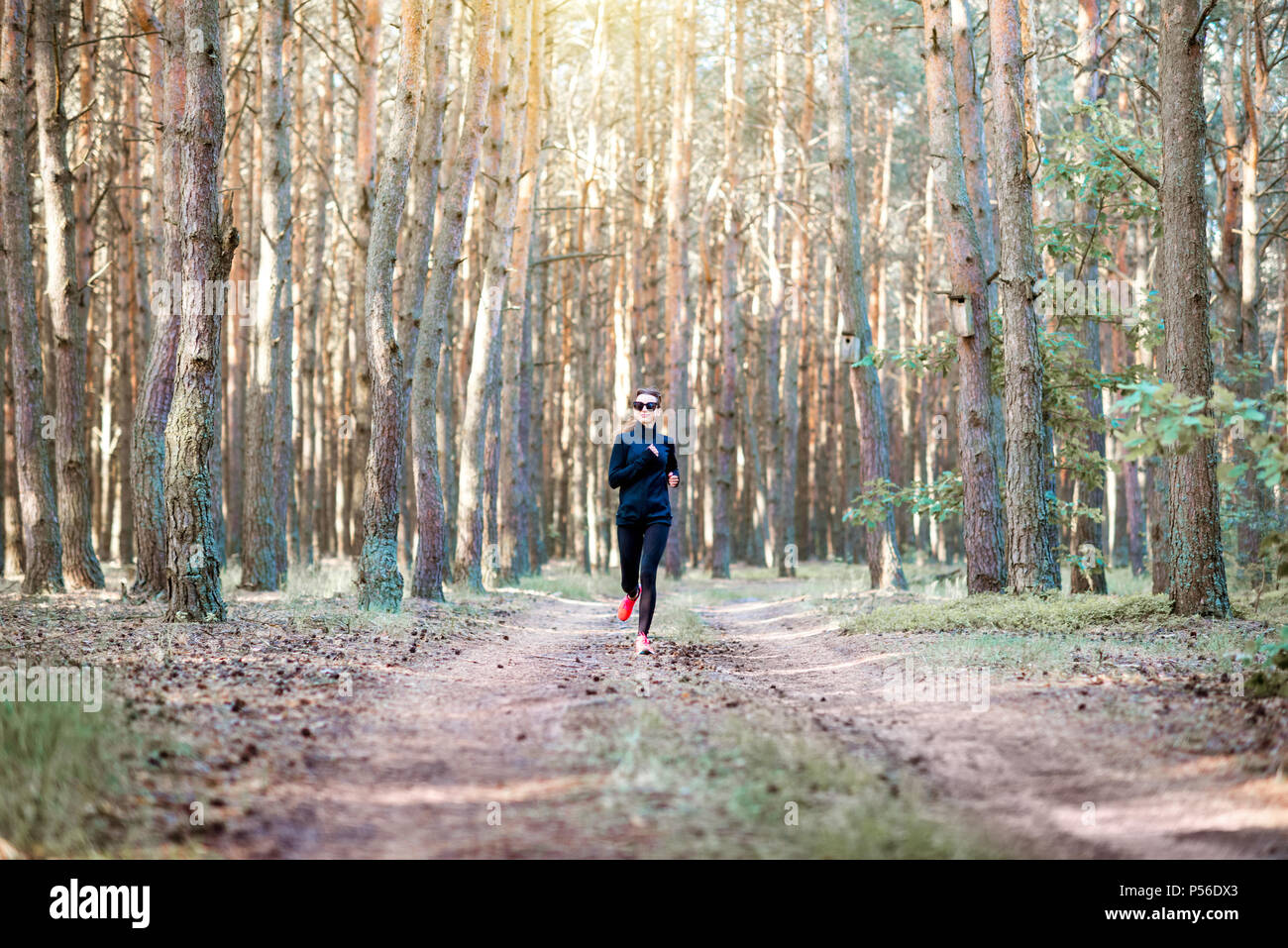 Woman running in the forest Stock Photo - Alamy