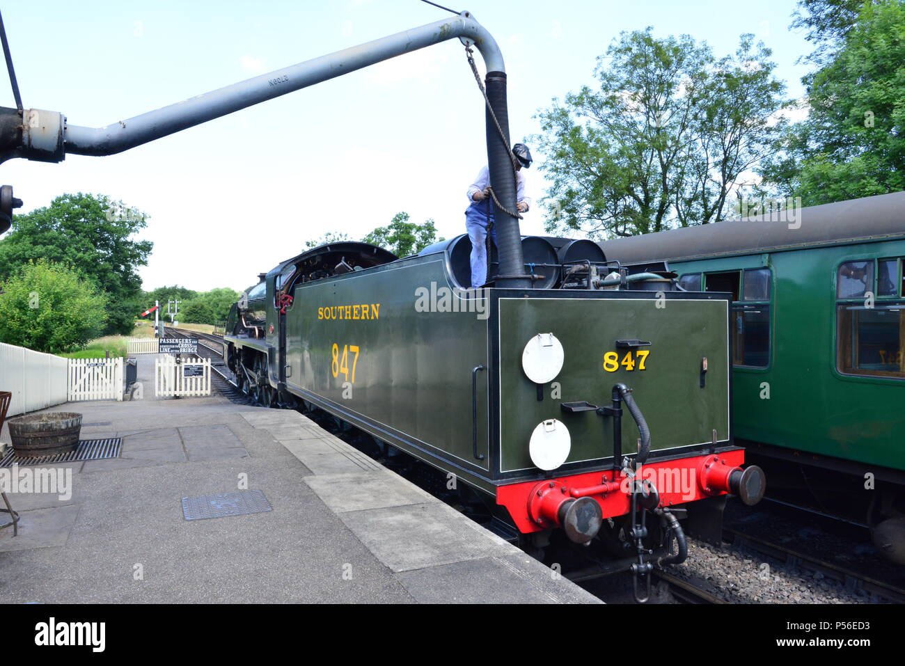 A steam train refueling with water Stock Photo - Alamy