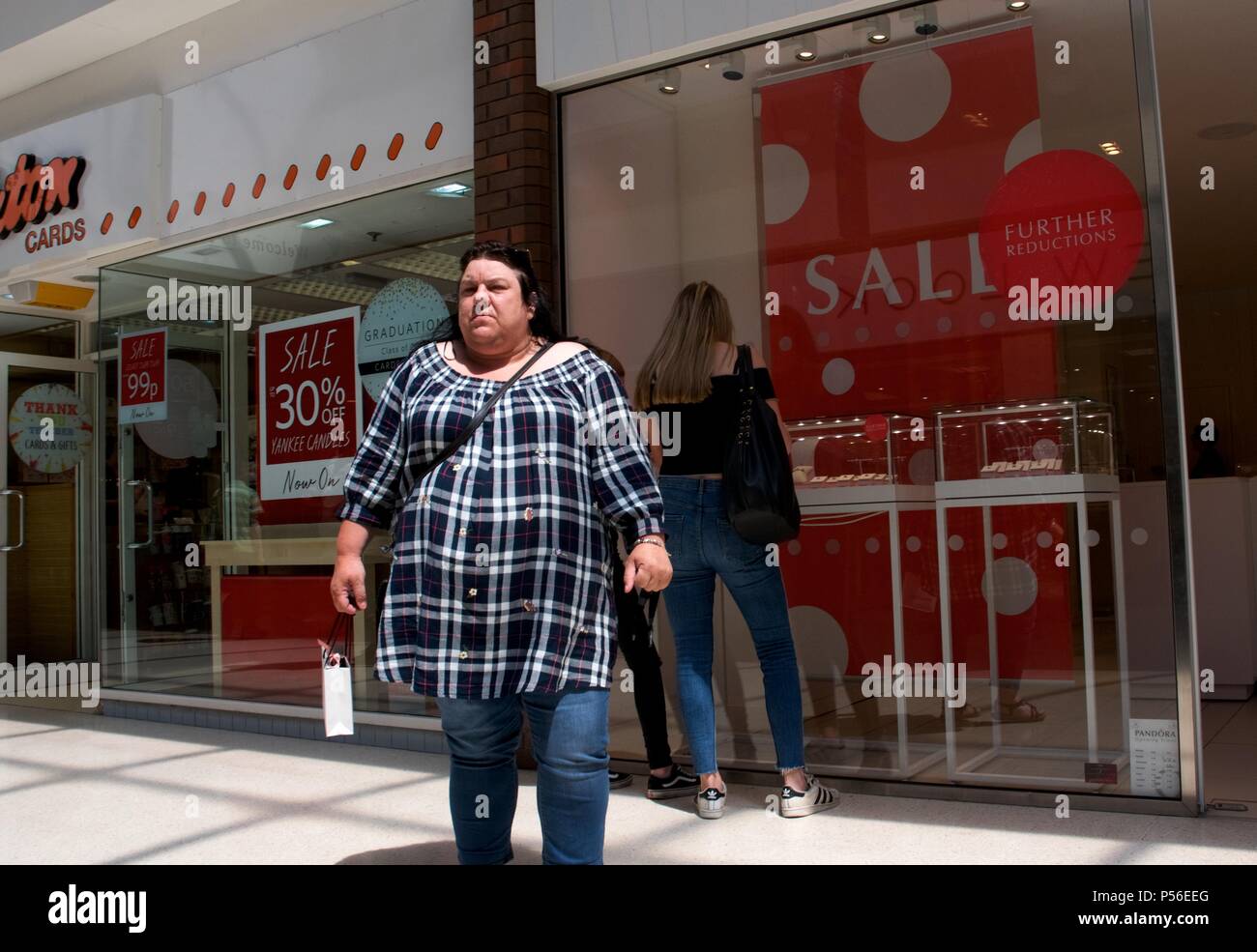 An overweight lady walks through the main shopping area in Buxton ...