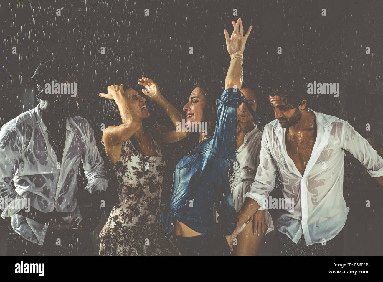 Groupof friends dncing in the rain Stock Photo - Alamy