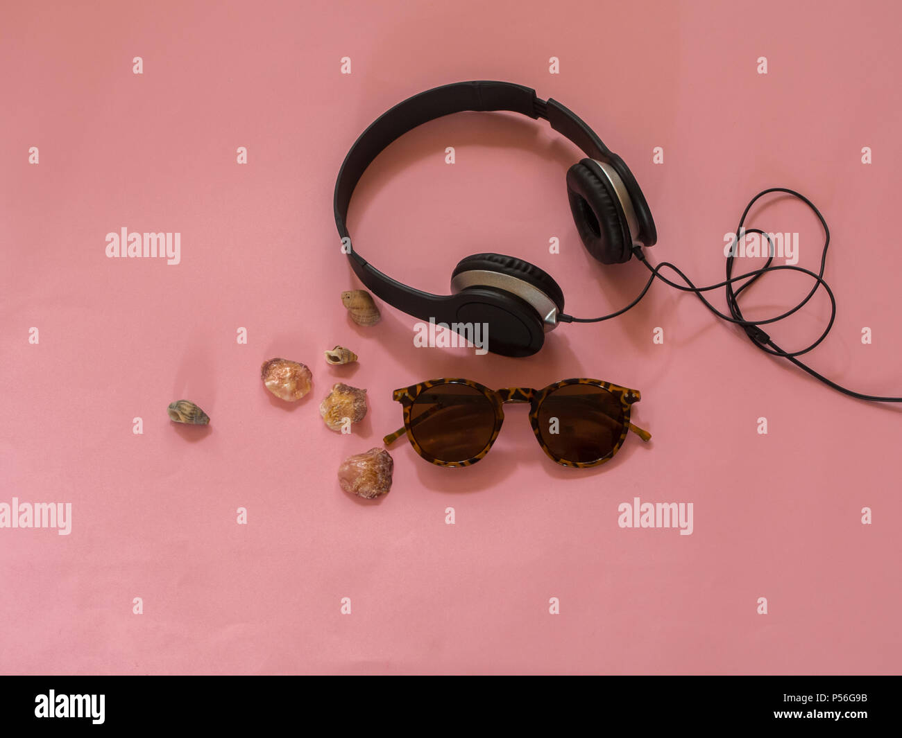 sunglasses, earphones and seashells on pink background - Summer concept ...
