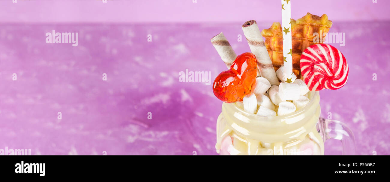 Freakshake from pink smoothie, cream. Monstershake with lollipops ...