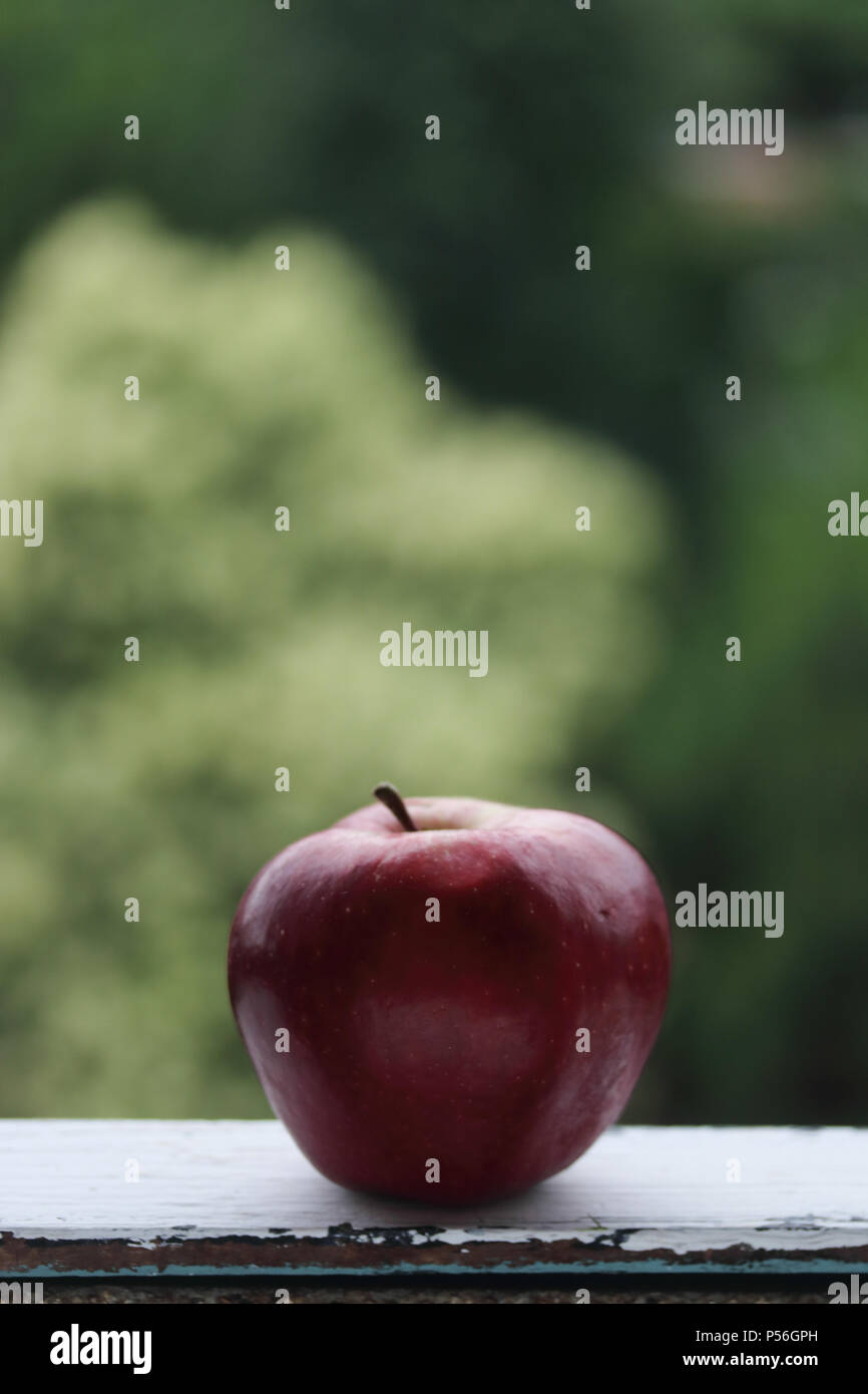 Red apple on a green background Stock Photo - Alamy