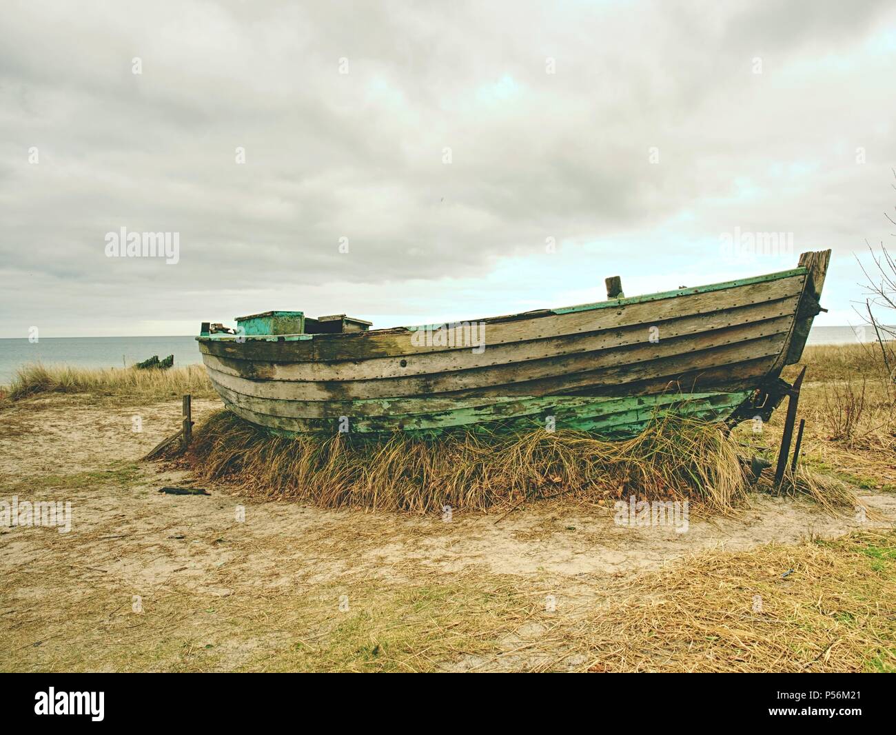 Small wrecked ship, wooden boat anchored at the sea, moody morning ...