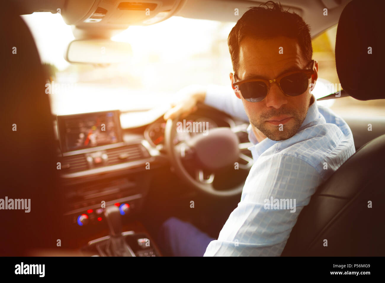 Man looking back while driving car Stock Photo - Alamy