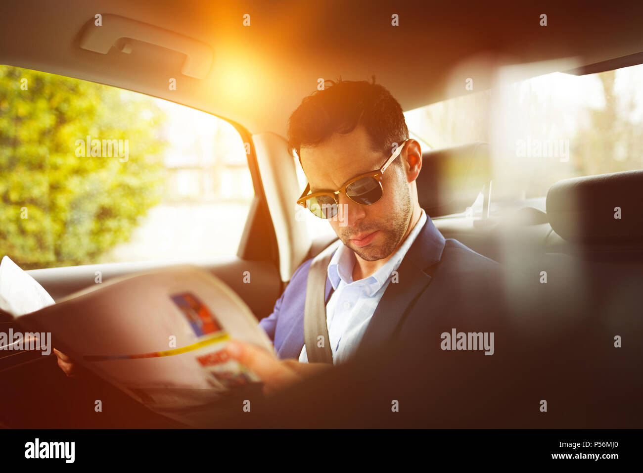 Man reading a newspaper in a car Stock Photo - Alamy