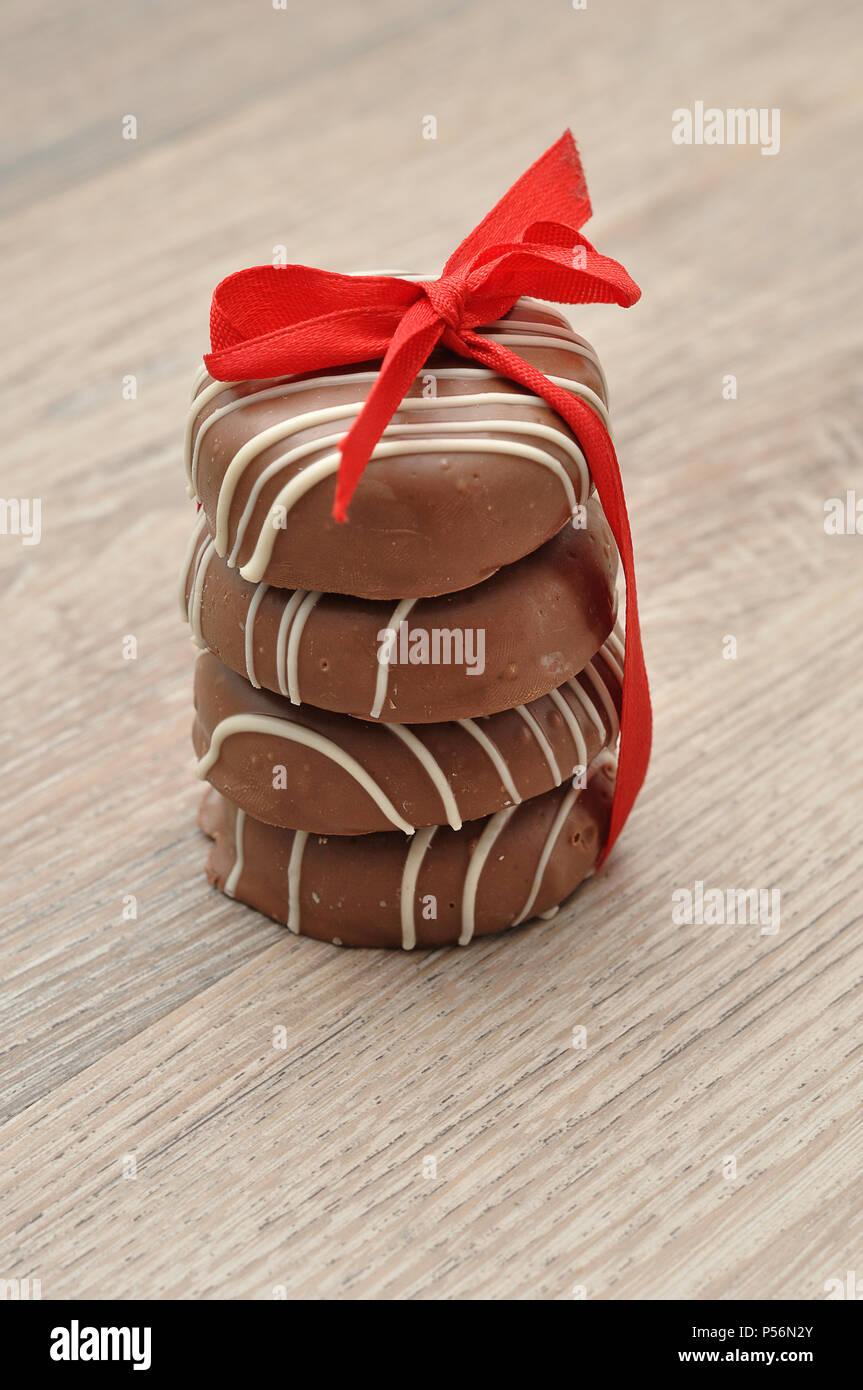 A stack of chocolate covered shortbread biscuits tied with a red ribbon ...