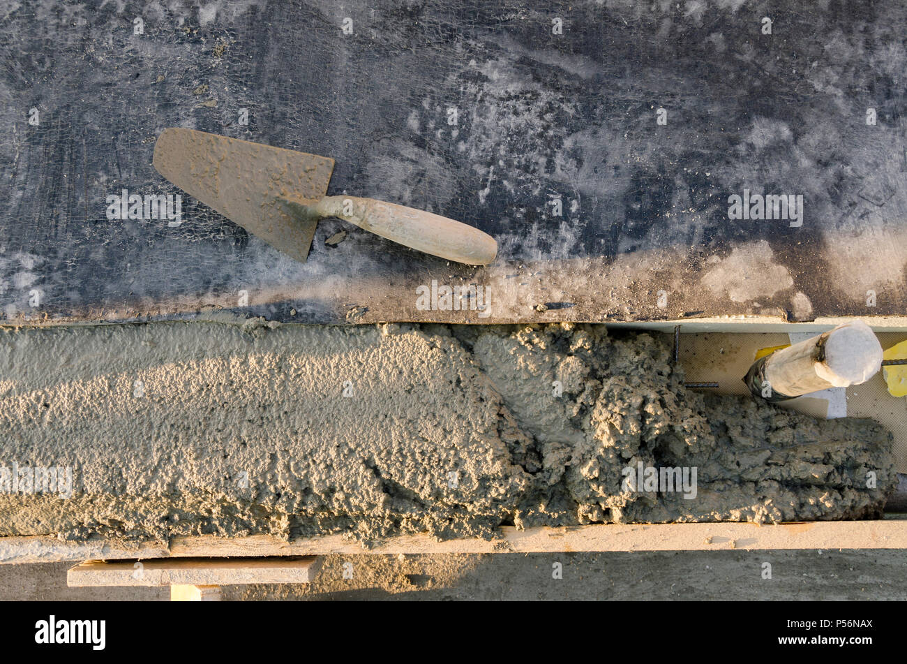 worker who throws cement on a building site for the renovation of a ...
