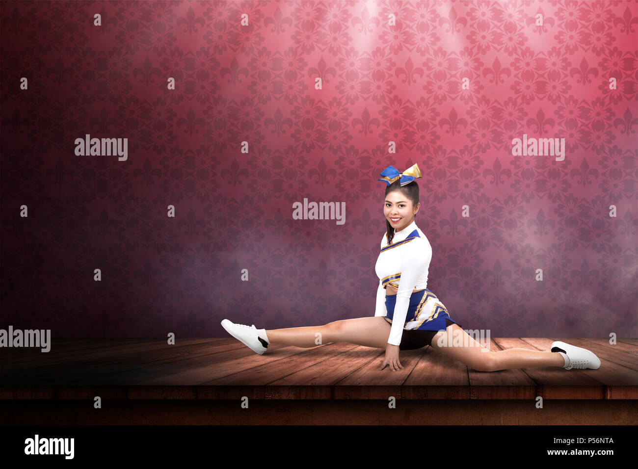 Smiling asian cheerleader doing splits on the stage Stock Photo - Alamy