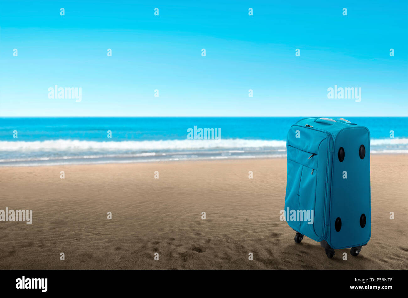 Blue suitcase on the beach. Summer travel concept Stock Photo - Alamy