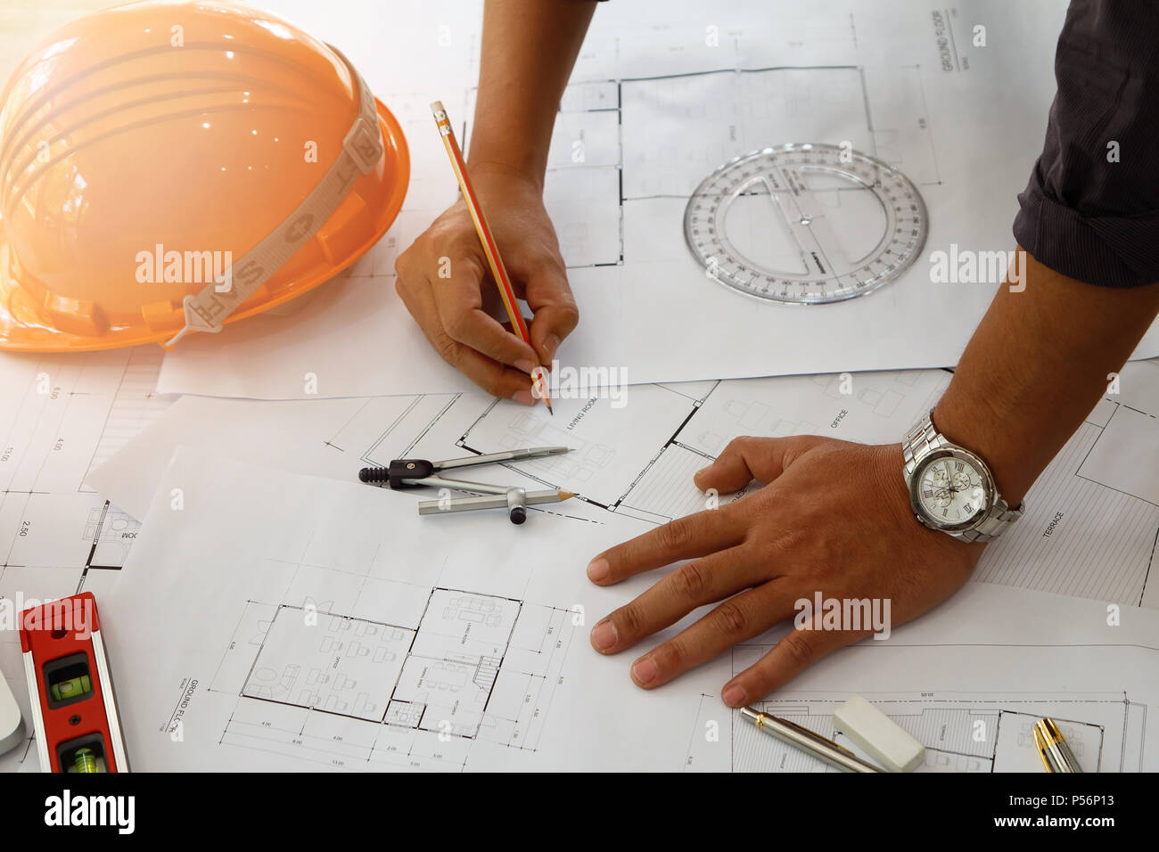 Architect or engineer using pencil and protractor working on blueprint ...