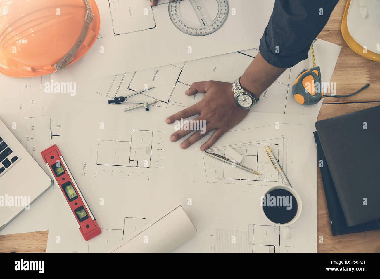 Architect or engineer using pencil and protractor working on blueprint ...