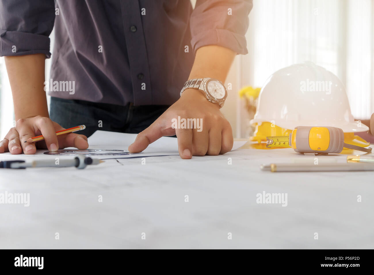 Architect or engineer using pencil and protractor working on blueprint ...