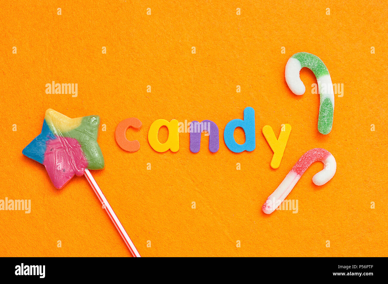 The word candy displayed with a star shape lollipop and candy canes ...