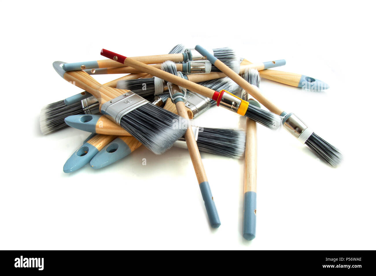 Pile of paint brushes isolated over white Stock Photo - Alamy